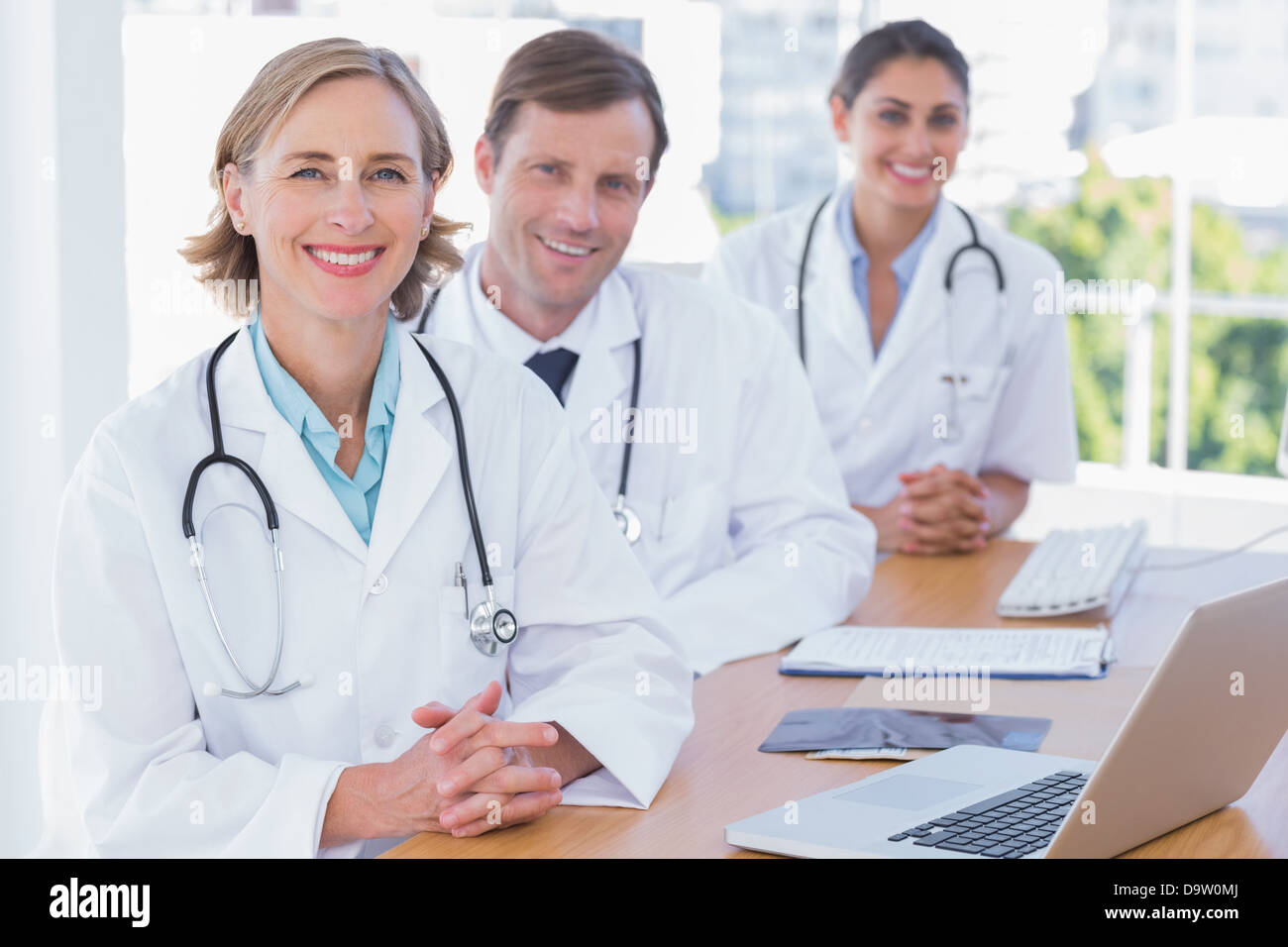 Cheerful doctors posing at their desk Stock Photo - Alamy