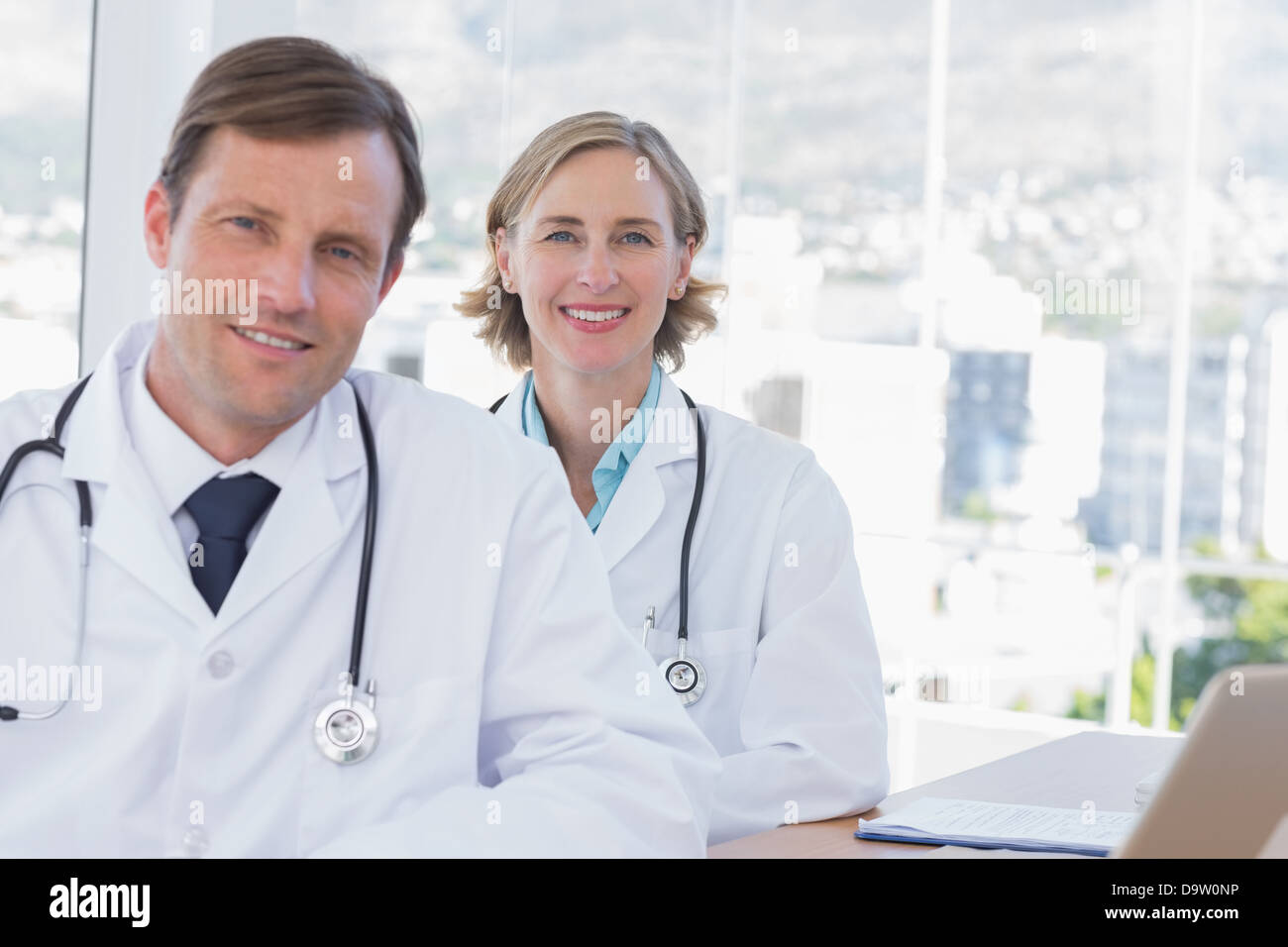 Cheerful group of doctors posing at their desk Stock Photo - Alamy