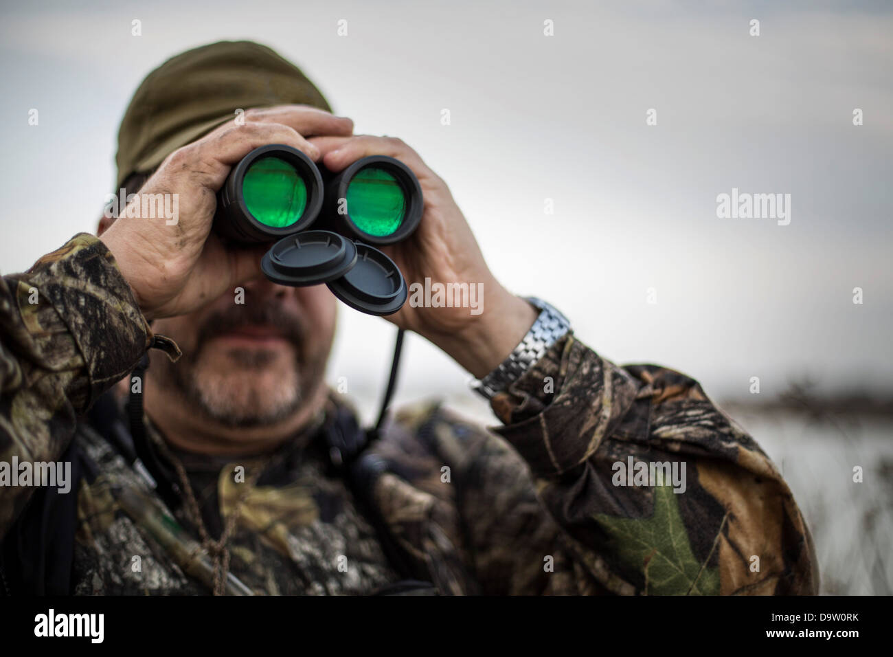 Duck hunter using binoculars Stock Photo - Alamy