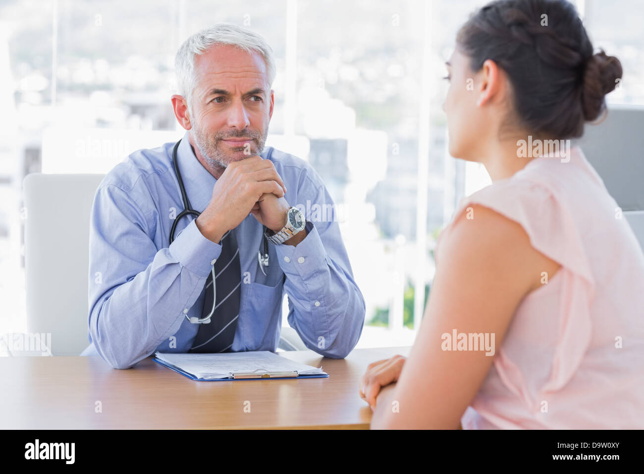 Concentrated doctor listening to patient Stock Photo - Alamy