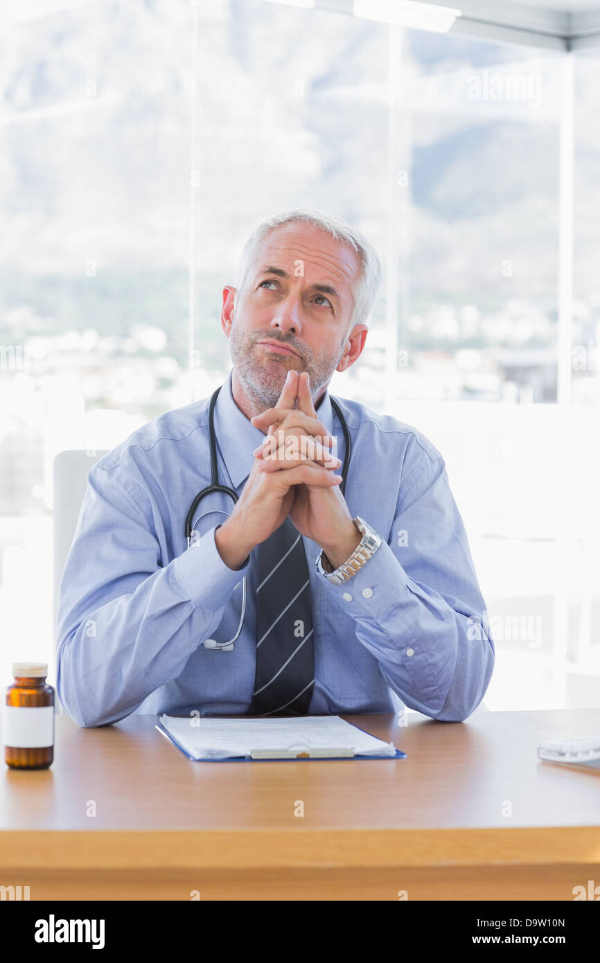 Handsome doctor thinking hi-res stock photography and images - Alamy