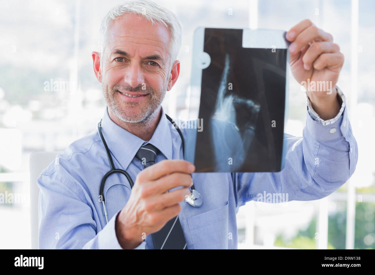 Smiling doctor holding a radiography Stock Photo - Alamy