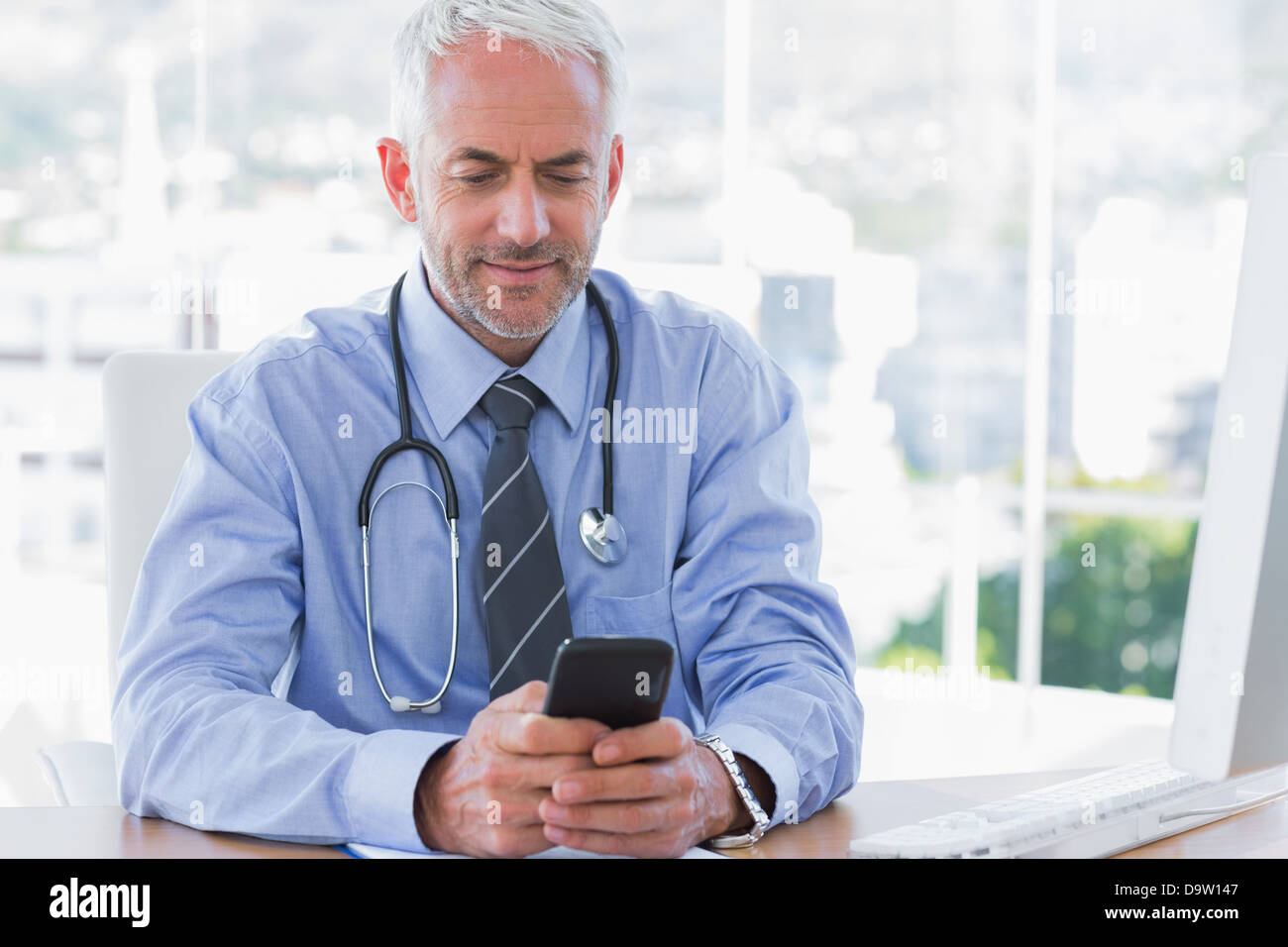 Doctor using his smartphone Stock Photo - Alamy
