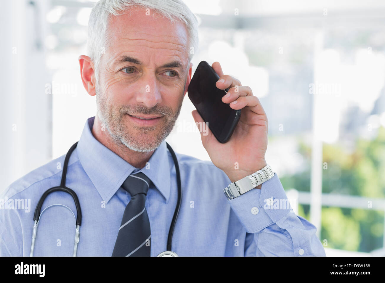 Mature doctor talking on mobile hi-res stock photography and images - Alamy