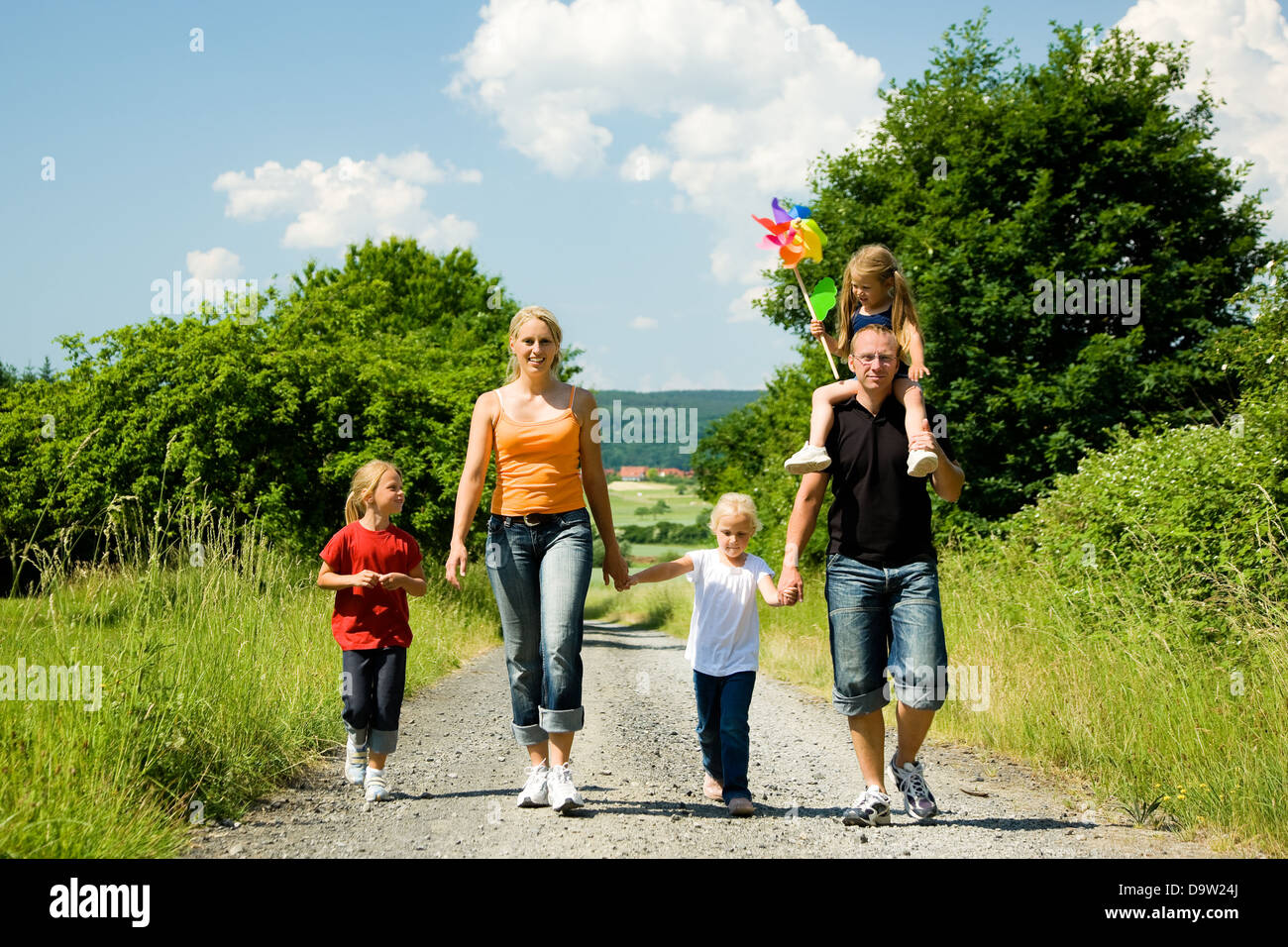 Family having a walk down a path on a sunny day under a perfect blue ...