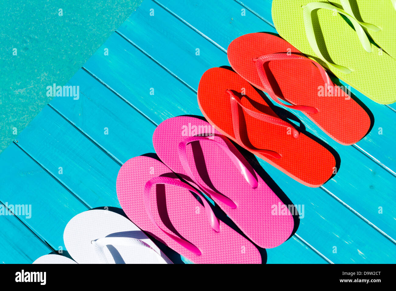 Colorful flip flops by a swimming pool Stock Photo - Alamy