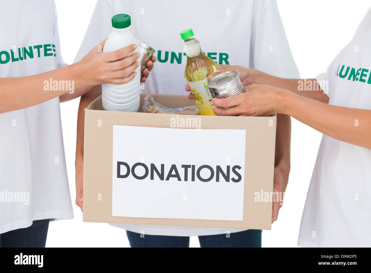 Group of volunteers putting food in donation box Stock Photo - Alamy
