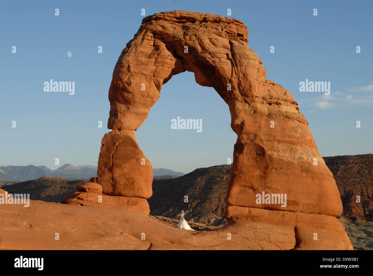 Bride standing under the Delicate Arch, Arches National Park, Utah, USA ...