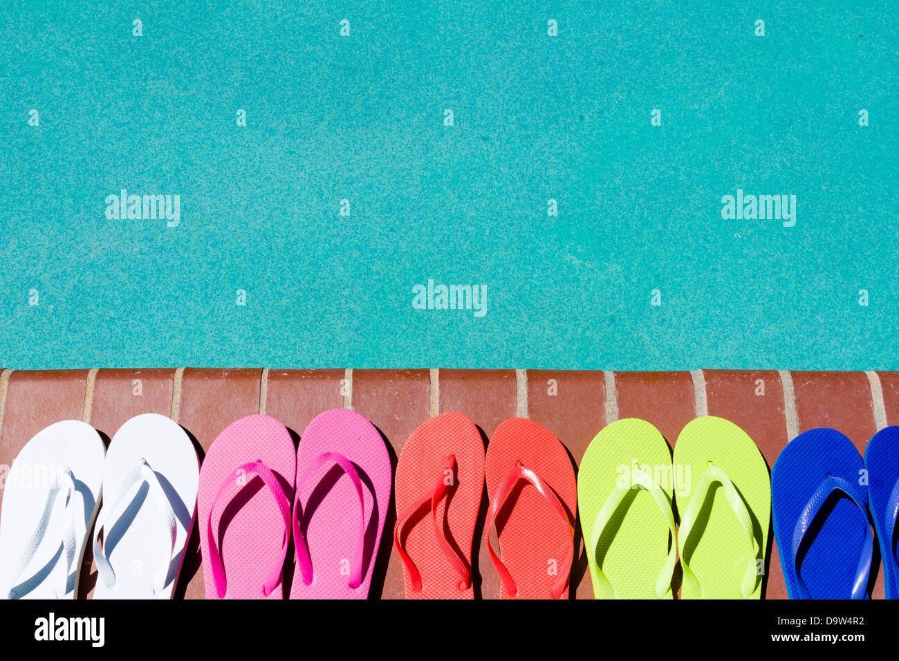 Colorful flip flops by a swimming pool Stock Photo - Alamy