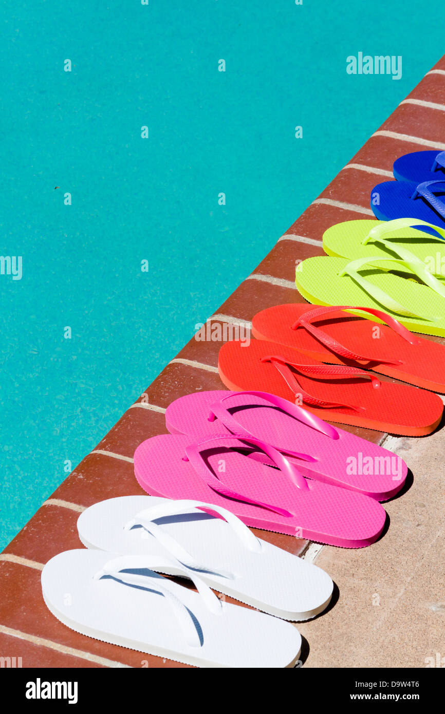 Colorful flip flops by a swimming pool Stock Photo - Alamy