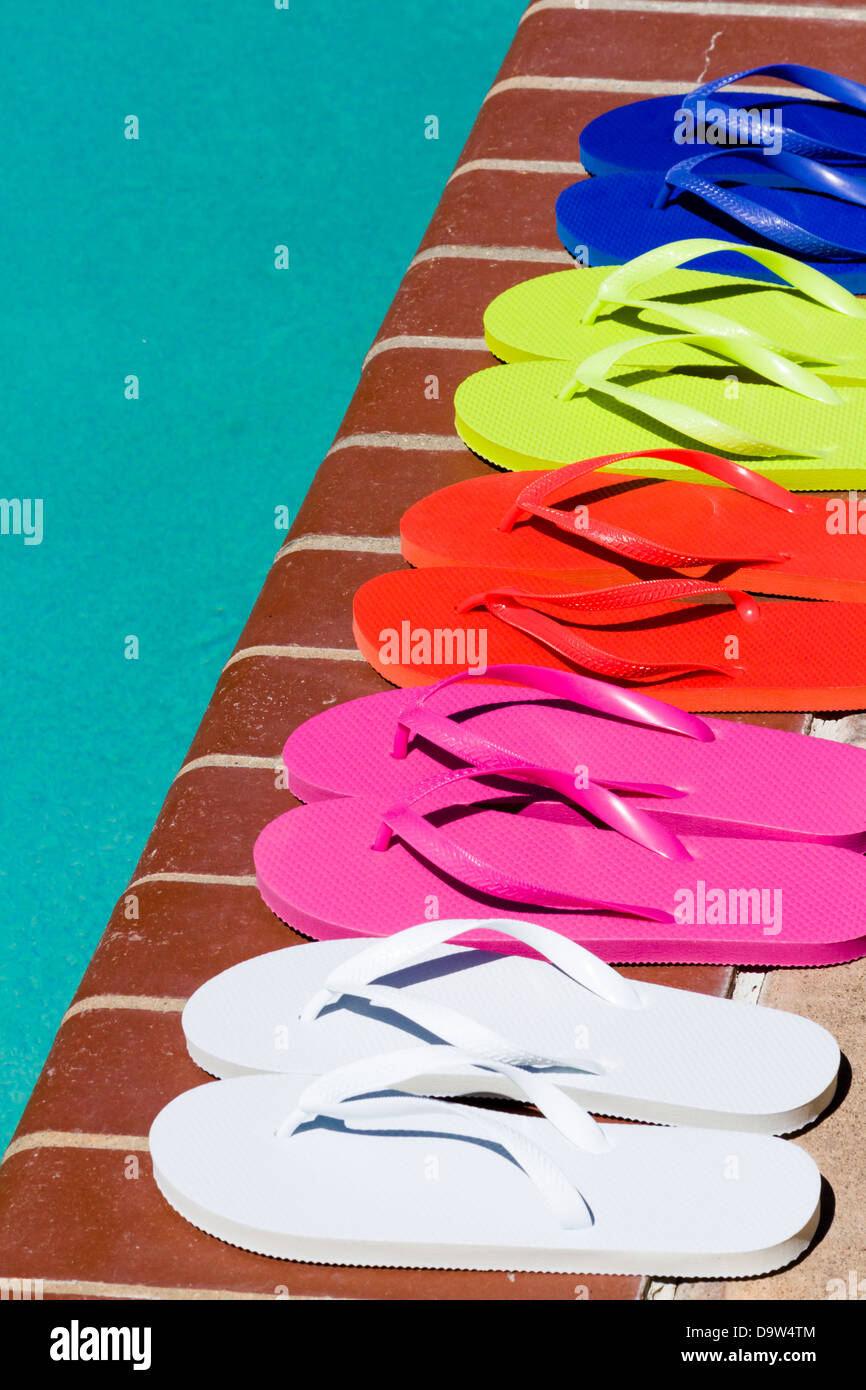 Colorful flip flops by a swimming pool Stock Photo - Alamy