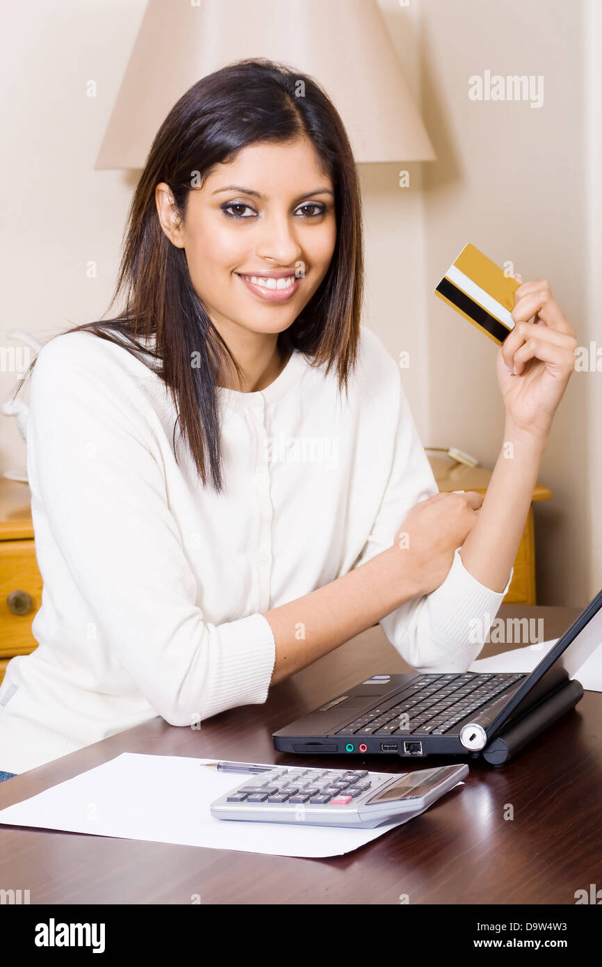 beautiful young woman holding a bank credit card and doing online ...