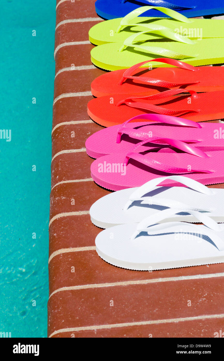 Colorful flip flops by a swimming pool Stock Photo - Alamy