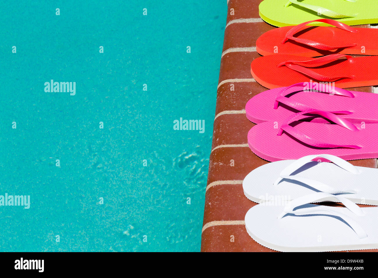 Colorful flip flops by a swimming pool Stock Photo - Alamy