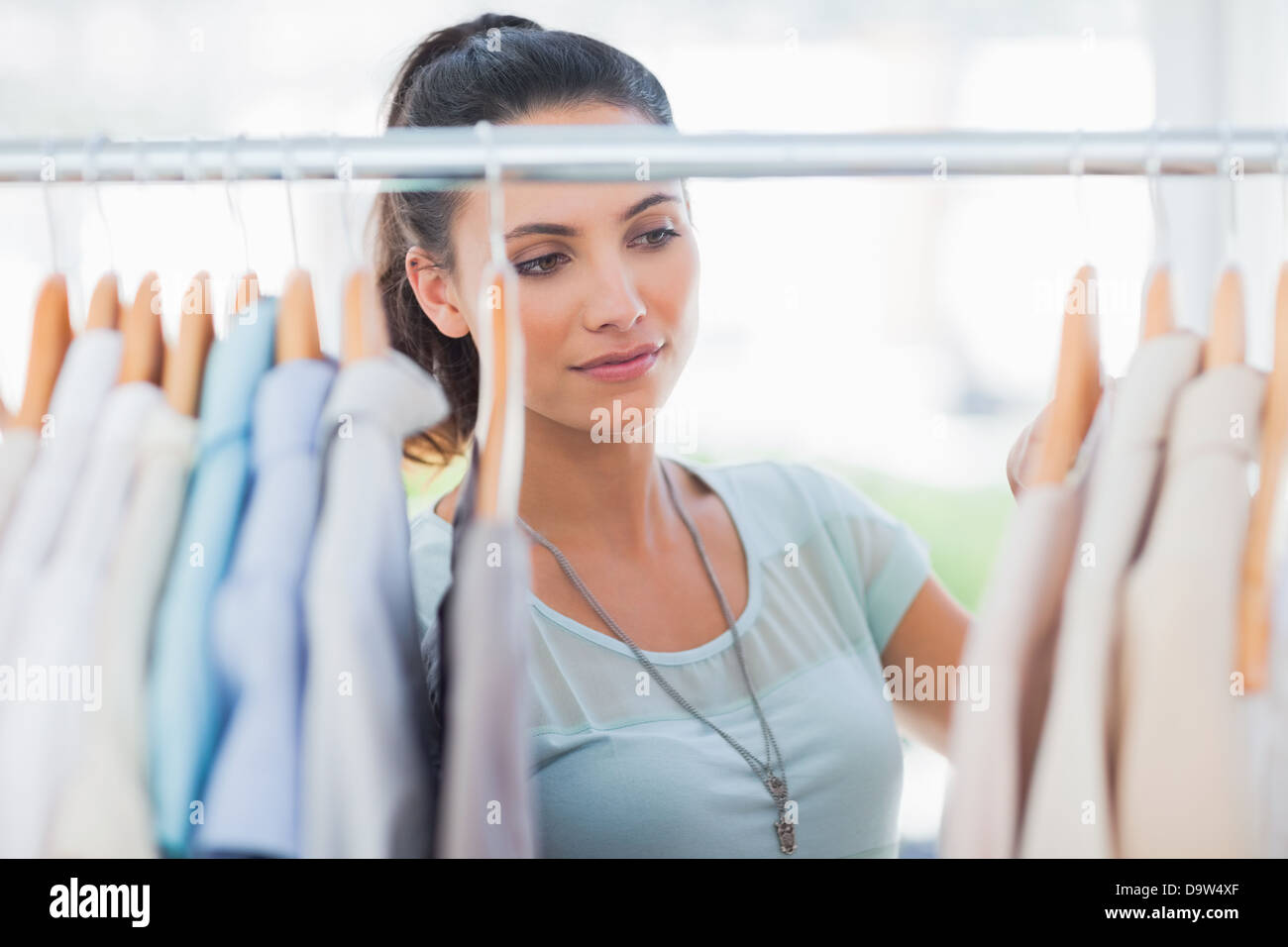 Attractive woman looking at clothes Stock Photo - Alamy