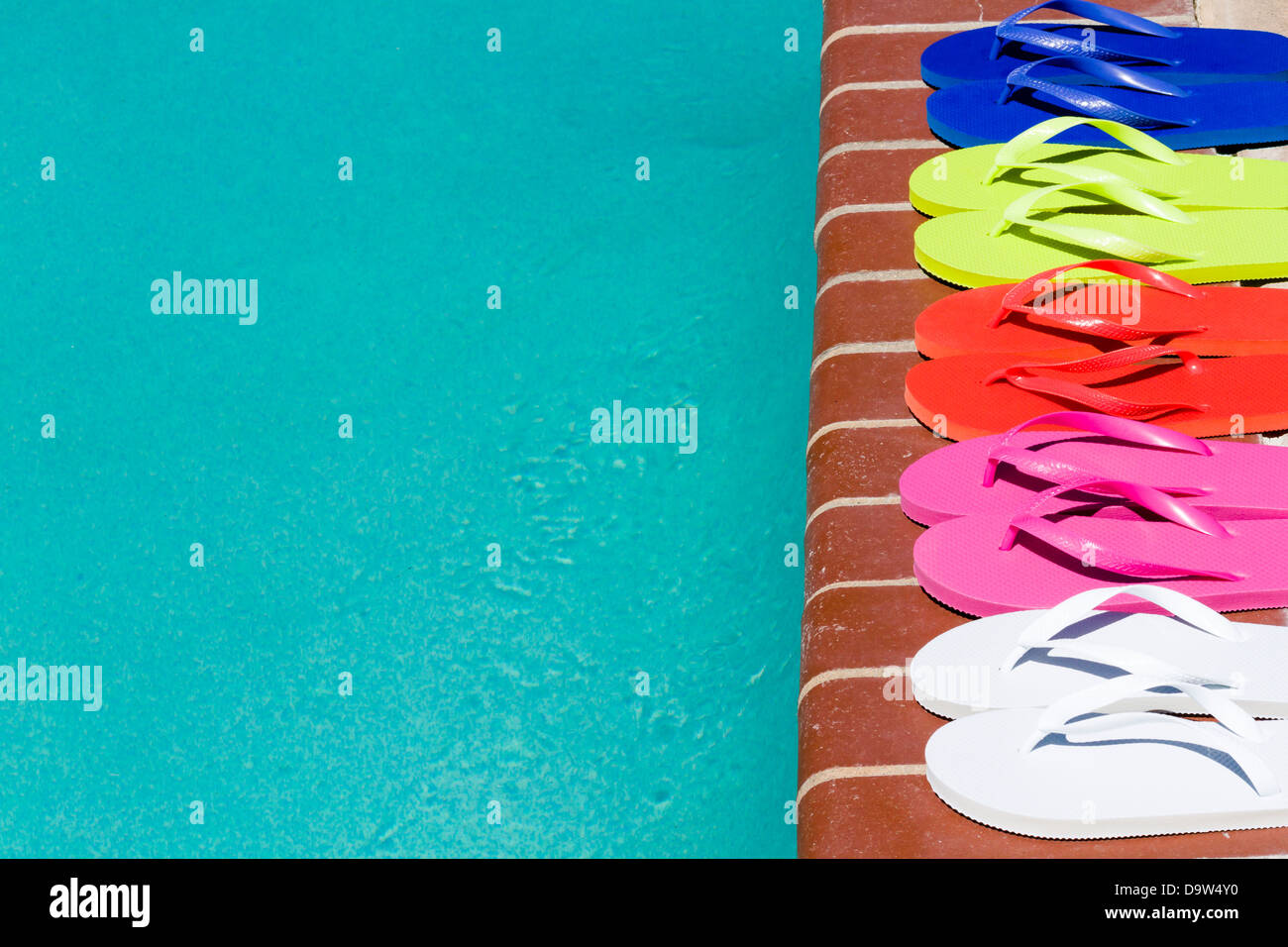 Colorful flip flops by a swimming pool Stock Photo - Alamy