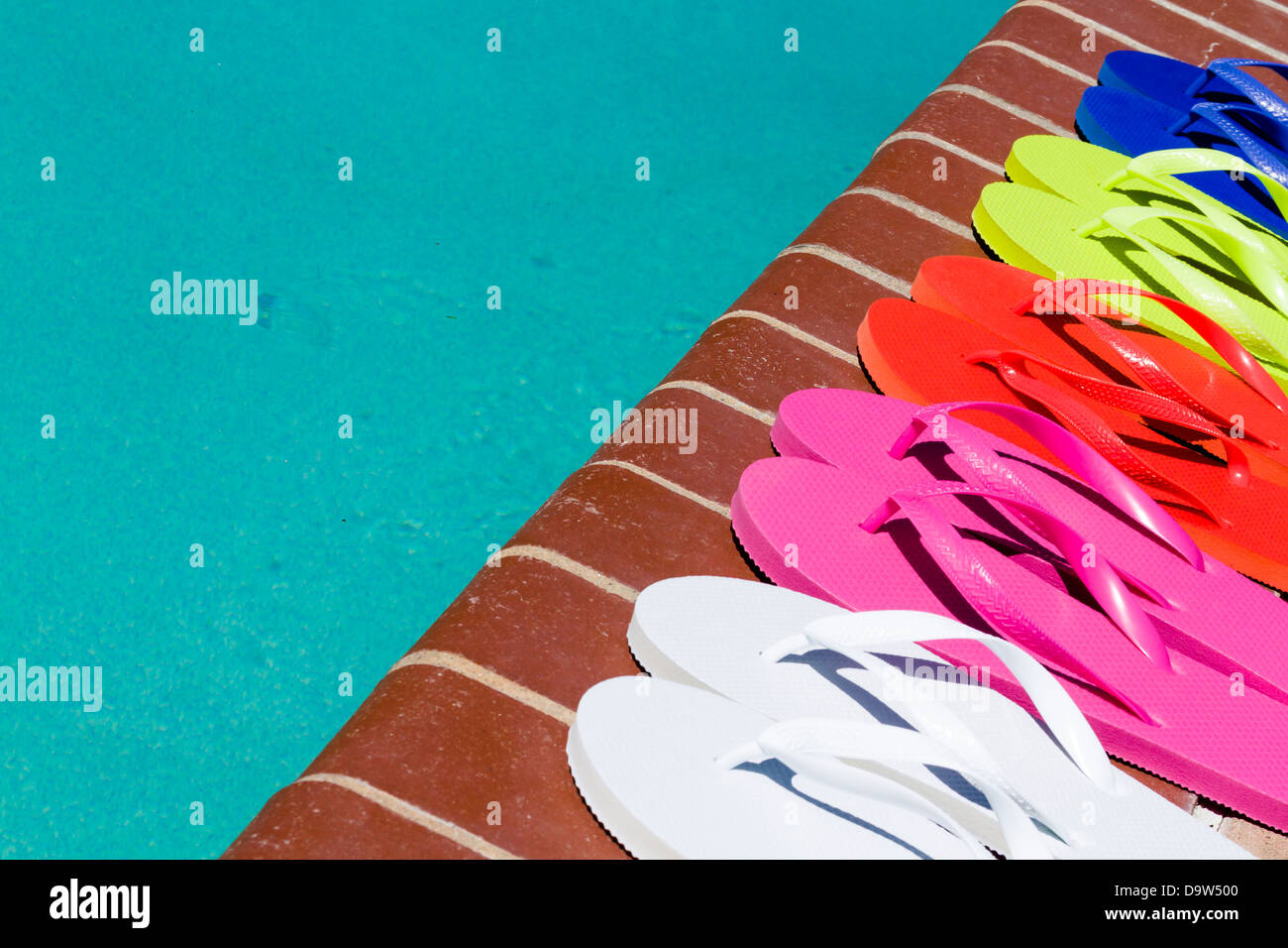 Colorful flip flops by a swimming pool Stock Photo - Alamy