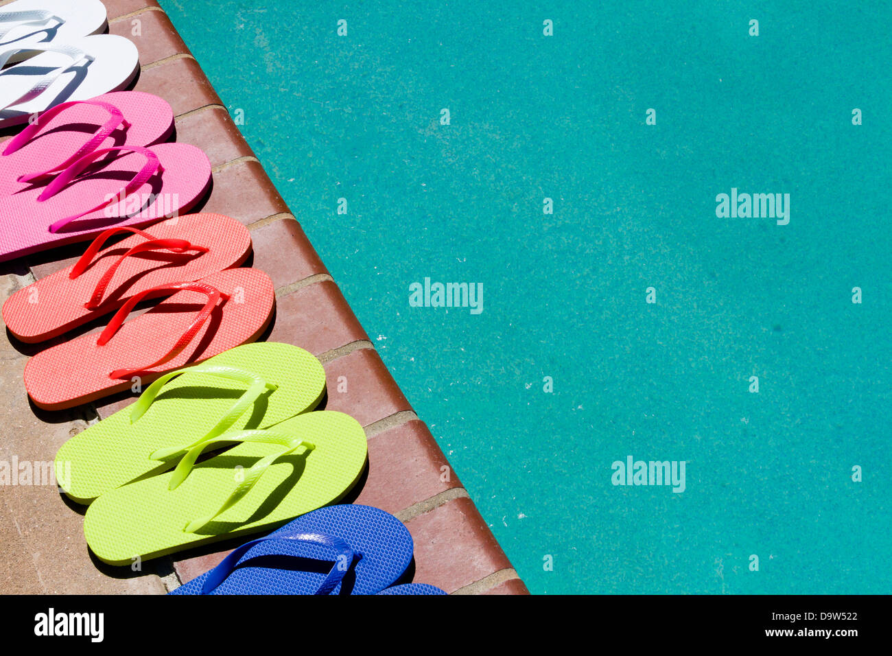 Colorful flip flops by a swimming pool Stock Photo - Alamy