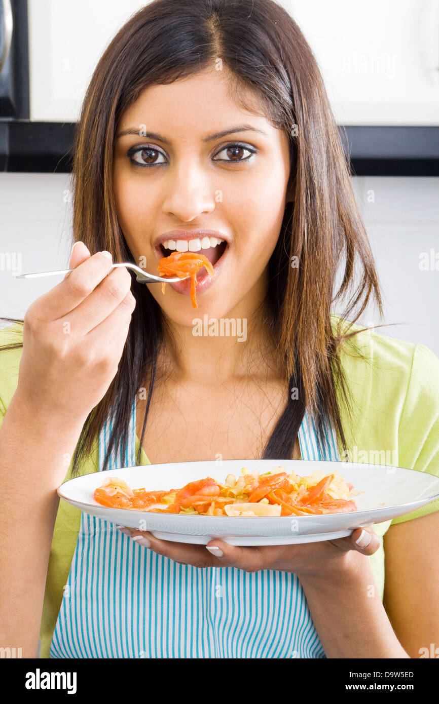beautiful young woman tasting food in kitchen Stock Photo - Alamy