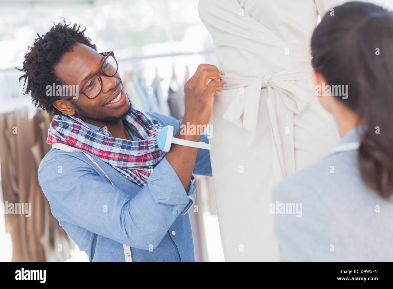 Cheerful fashion designers standing next to a model Stock Photo - Alamy