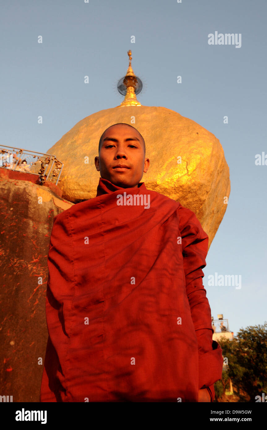 Monk standing before the pagoda on golden rock, Kyaiktiyo Pagoda ...