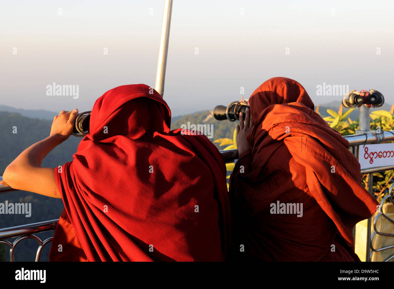 Pilgrim monks watching the scenery with binoculars at pagoda on the ...