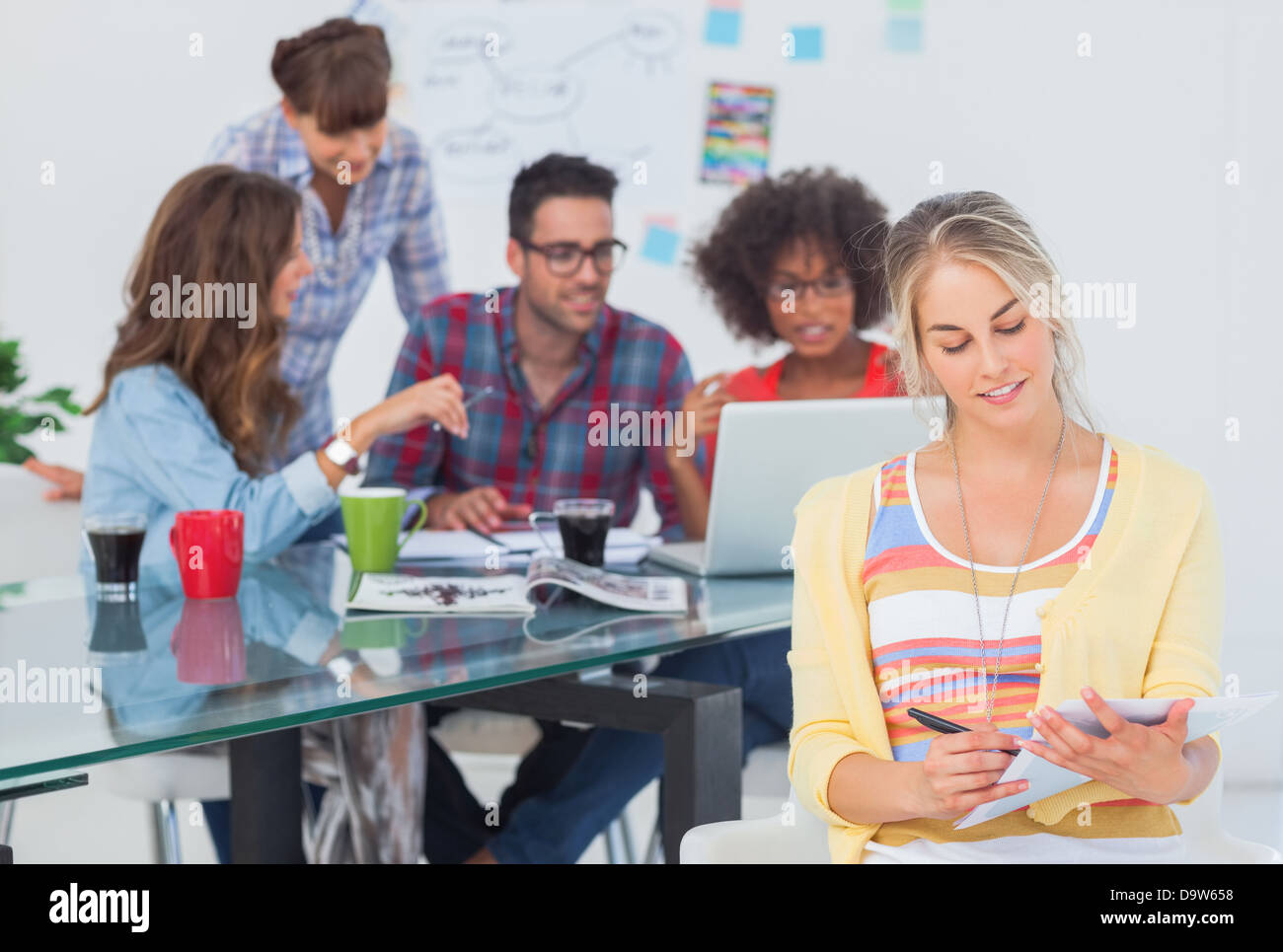 Pretty designer writing on a notepad Stock Photo - Alamy