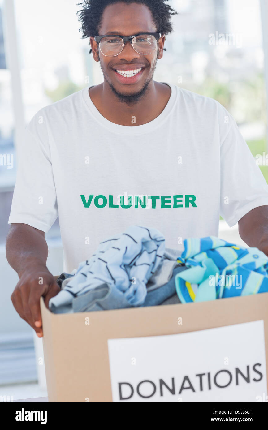 Cheerful man holding donation box Stock Photo - Alamy