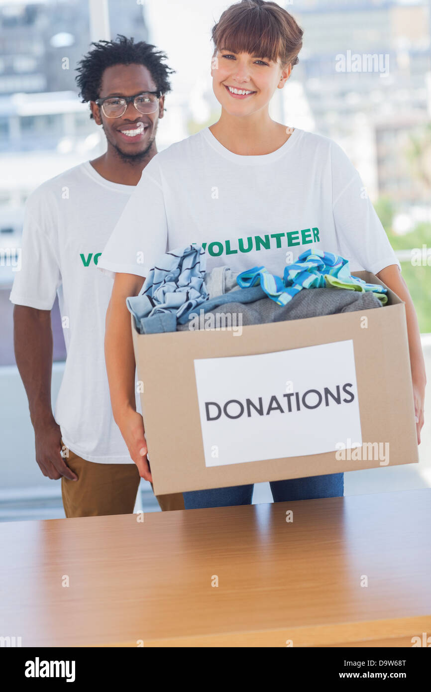 Cheerful woman holding donation box Stock Photo - Alamy