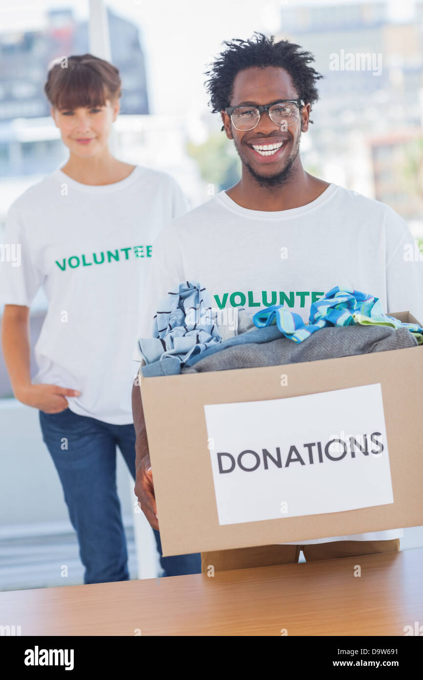 Handsome man holding donation box next to a colleague Stock Photo - Alamy