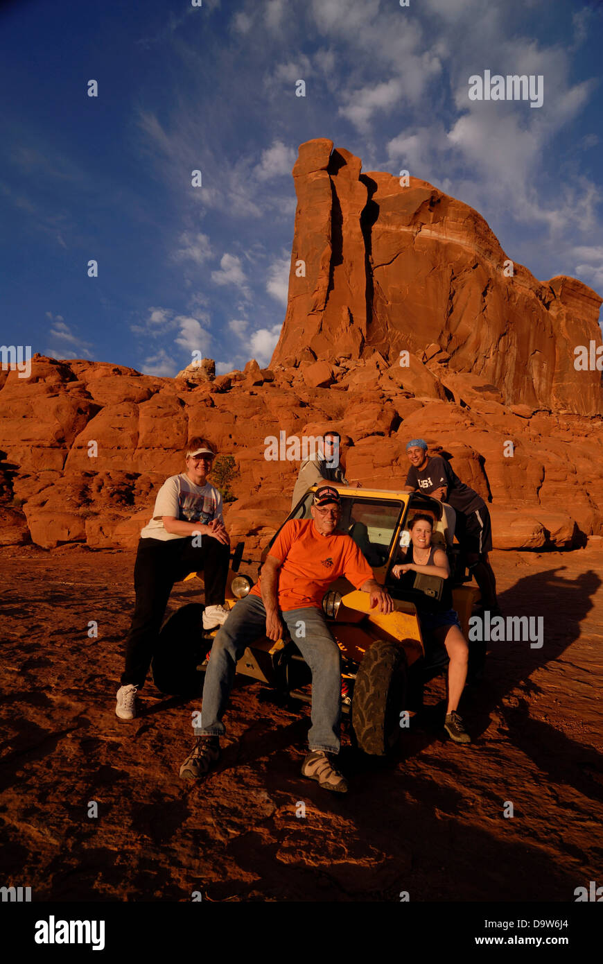 Tourists posing on tomcar a little Israeli buggy jeep at Arches ...