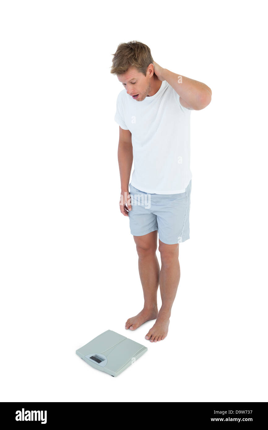 Man being astonished while looking at a weighing scale Stock Photo - Alamy