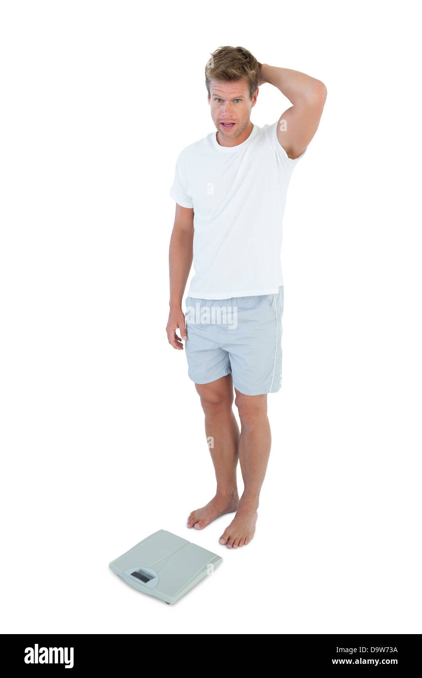 Man shocked in front of a weighing scale Stock Photo - Alamy