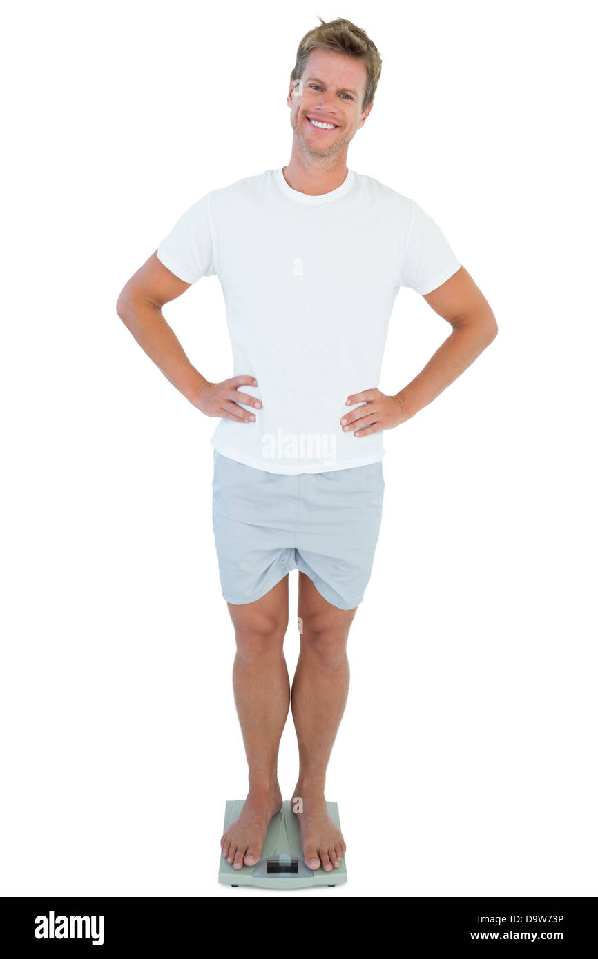 Cheerful man standing on a weighing scale Stock Photo - Alamy