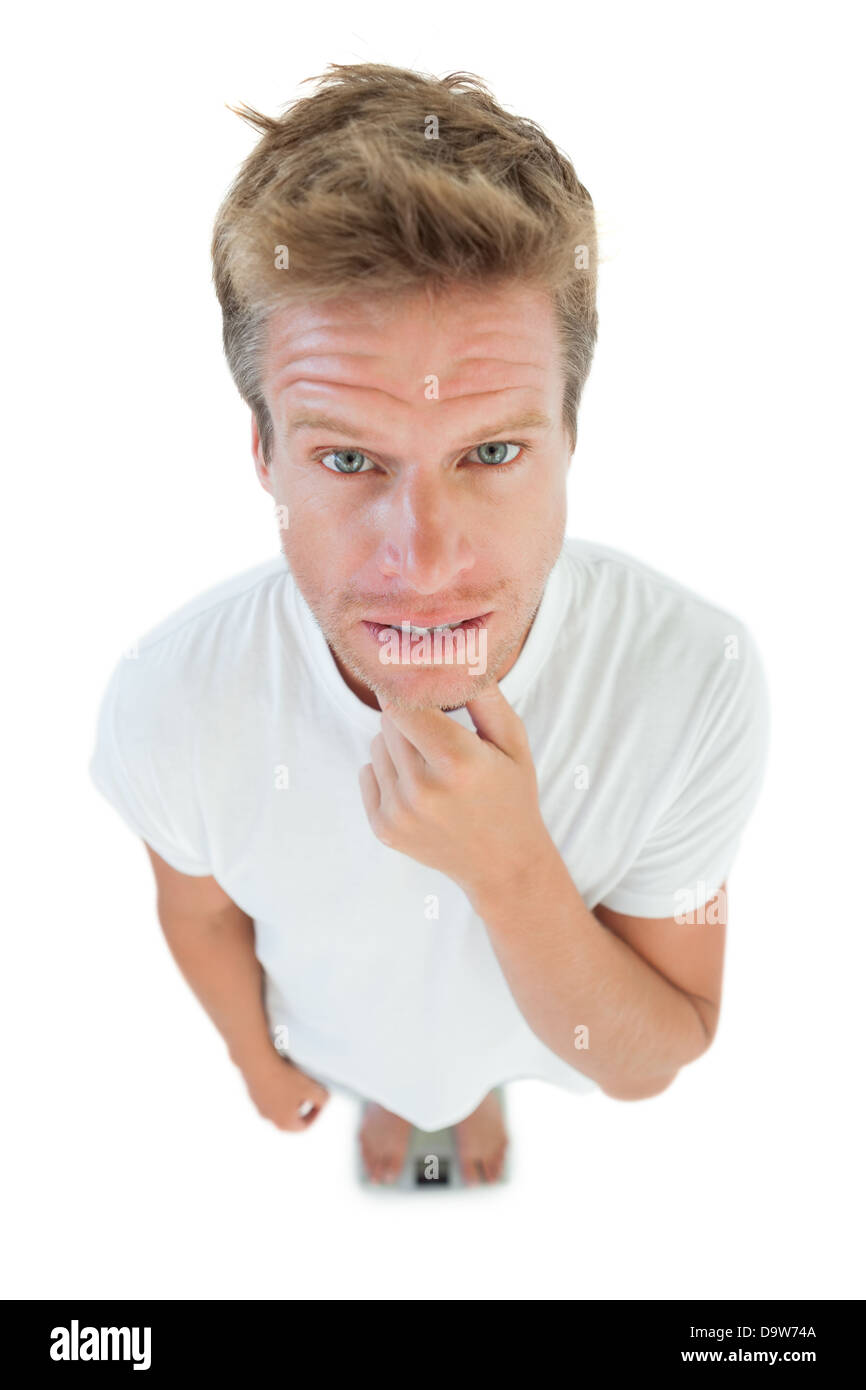 Doubtful man on a weighing scale Stock Photo - Alamy