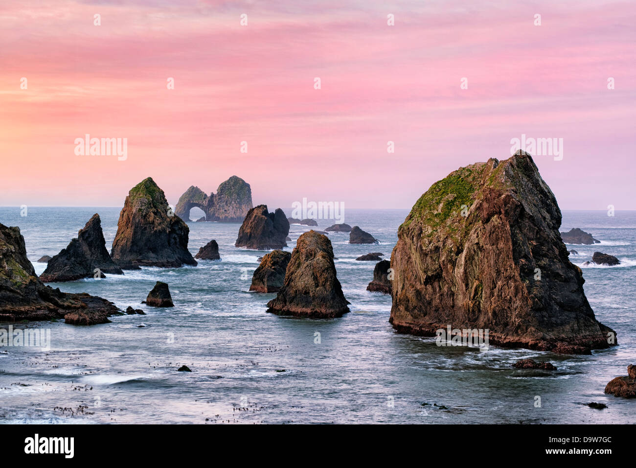 Dawn reveals the many offshore sea stacks including Mack Arch on Oregon ...