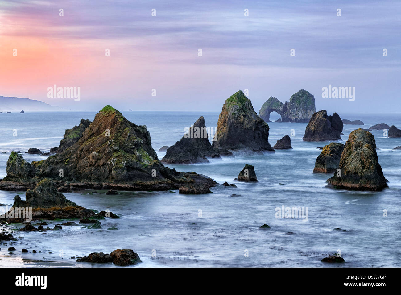 Dawn reveals the many offshore sea stacks including Mack Arch on Oregon ...