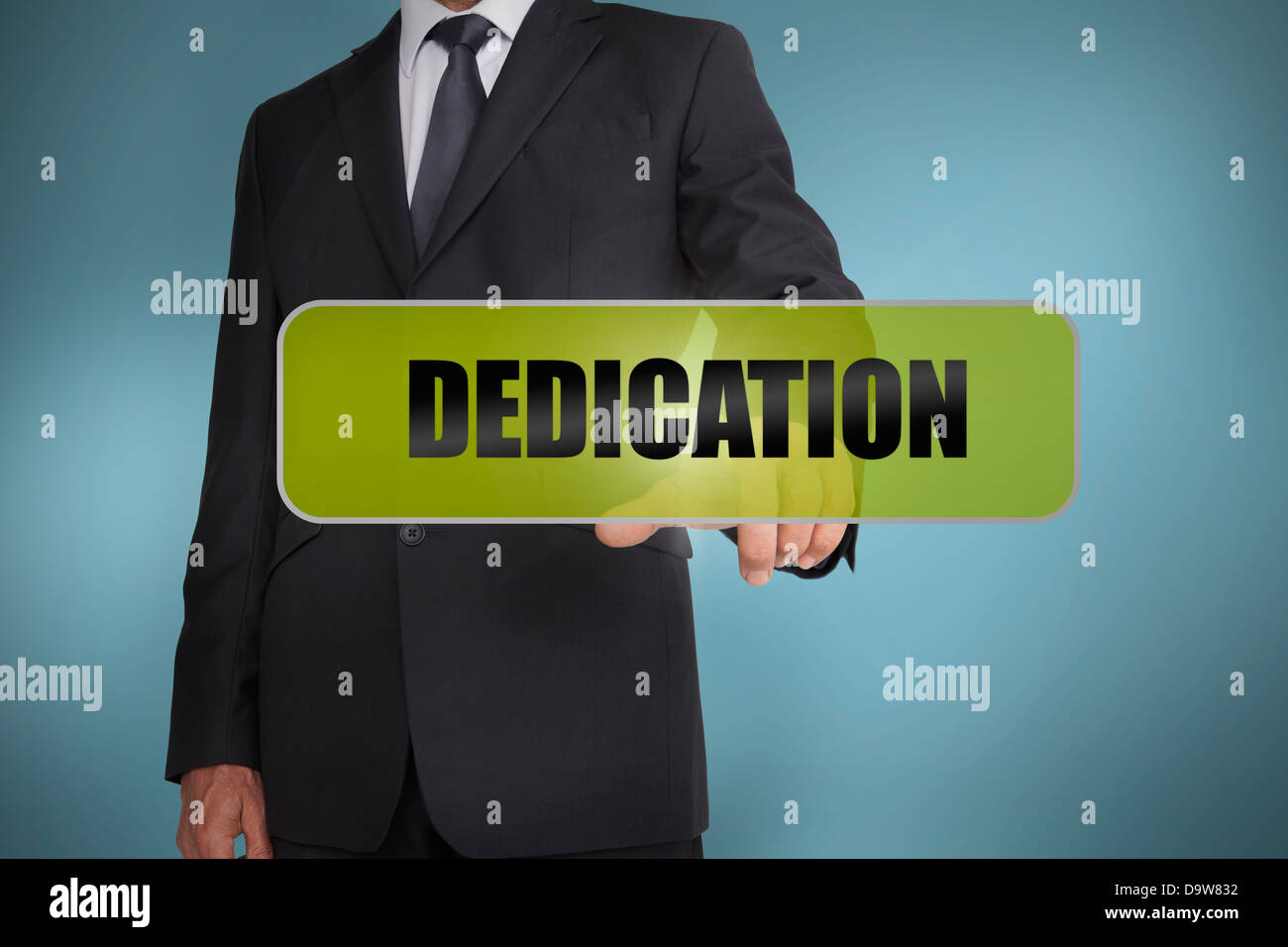 Businessman touching the word dedication written on green tag Stock ...