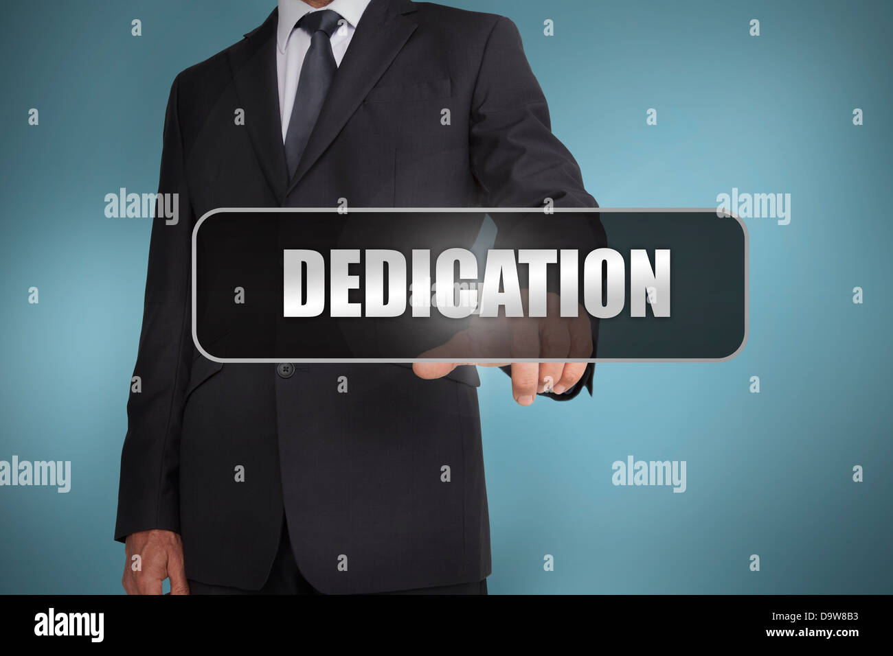 Businessman touching the word dedication written on black tag Stock ...