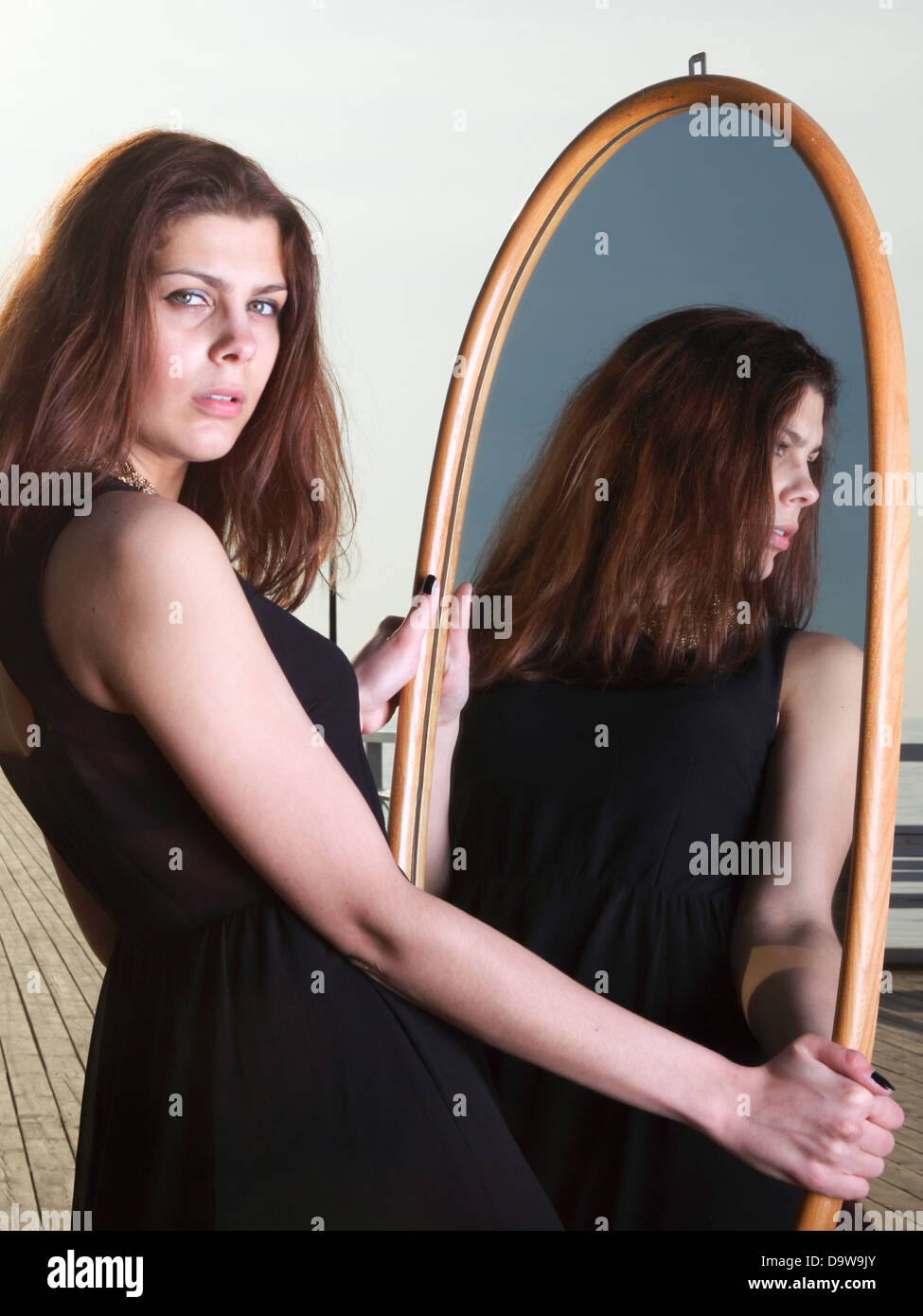 thoughtful young woman looks at the reflection in the mirror - solitude ...