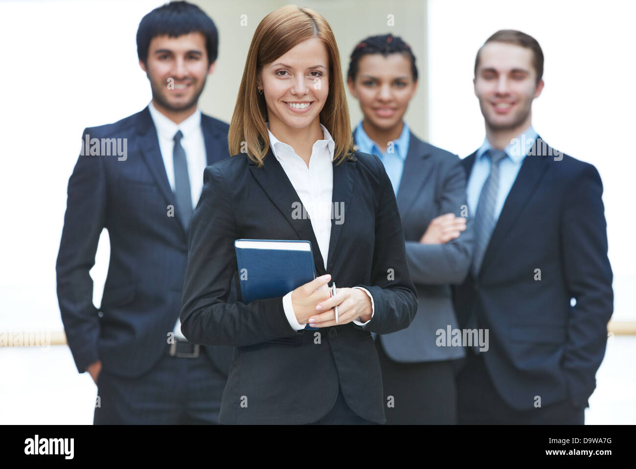 Group of friendly businesspeople with happy female leader in front ...