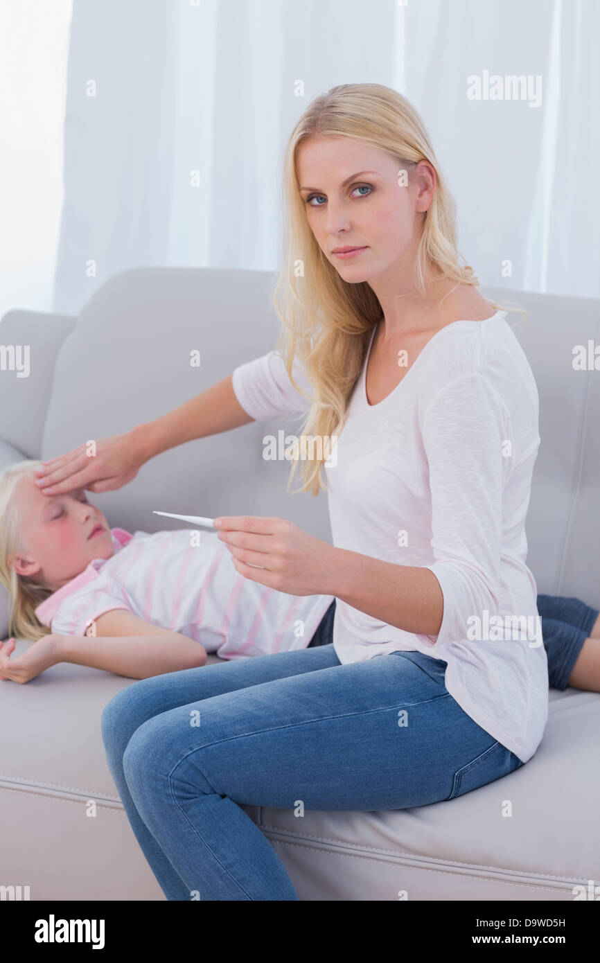 Concerned mother checking her daughters temperature Stock Photo - Alamy