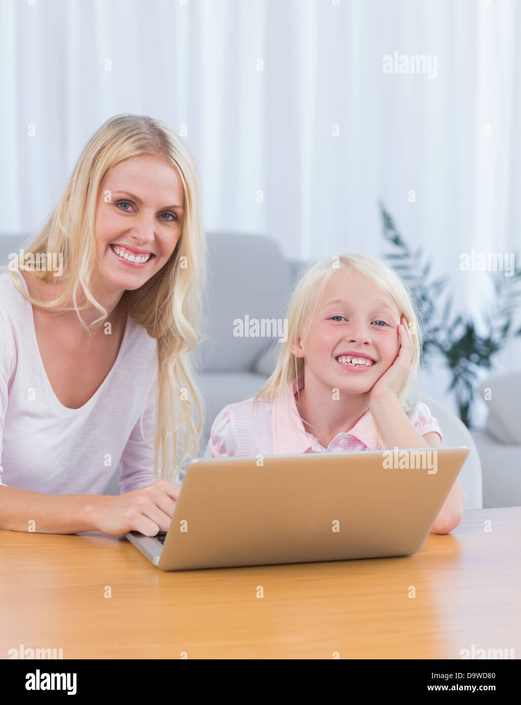 Mother and daughter using laptop in the living room Stock Photo - Alamy