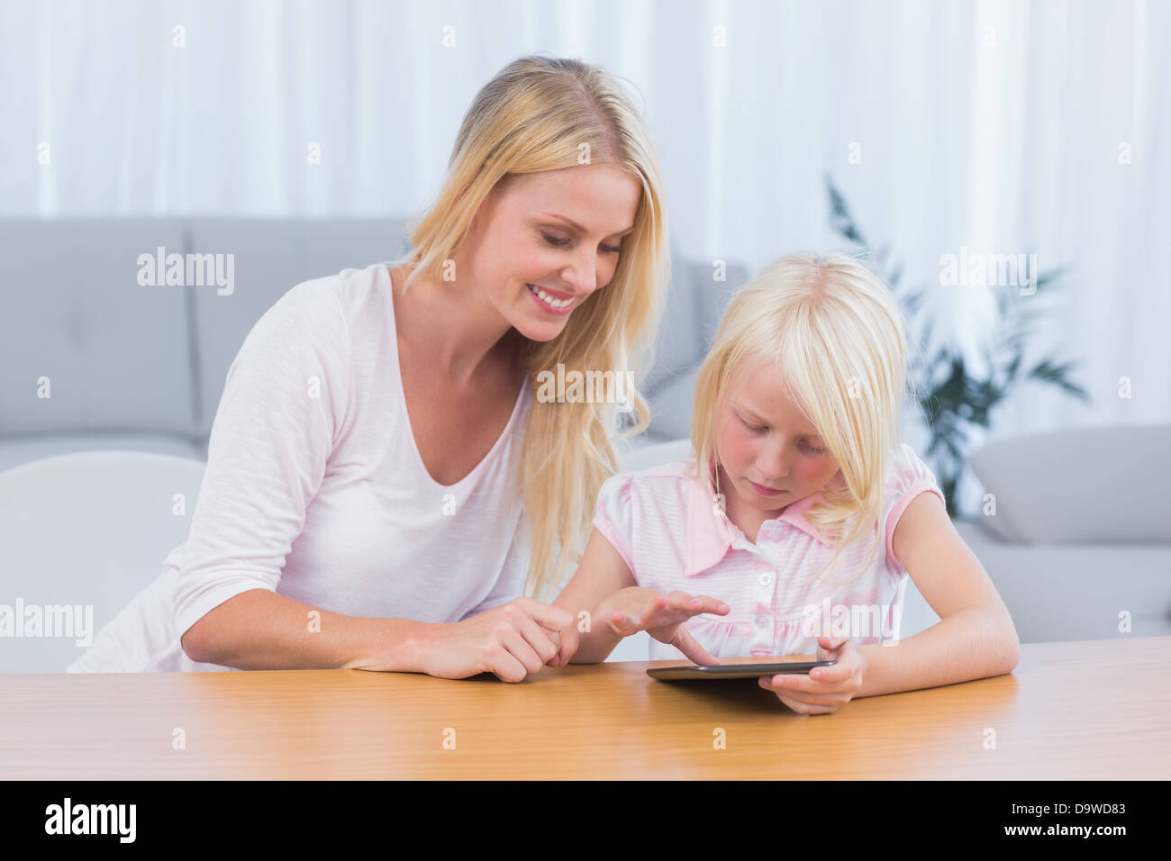 Mother using digital tablet with her daughter Stock Photo - Alamy