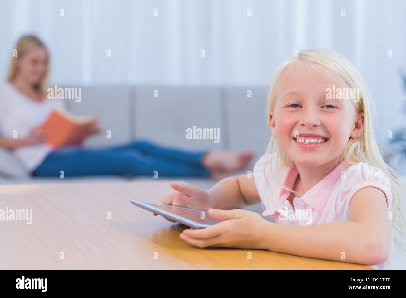 Little girl using tablet pc in the living room Stock Photo - Alamy