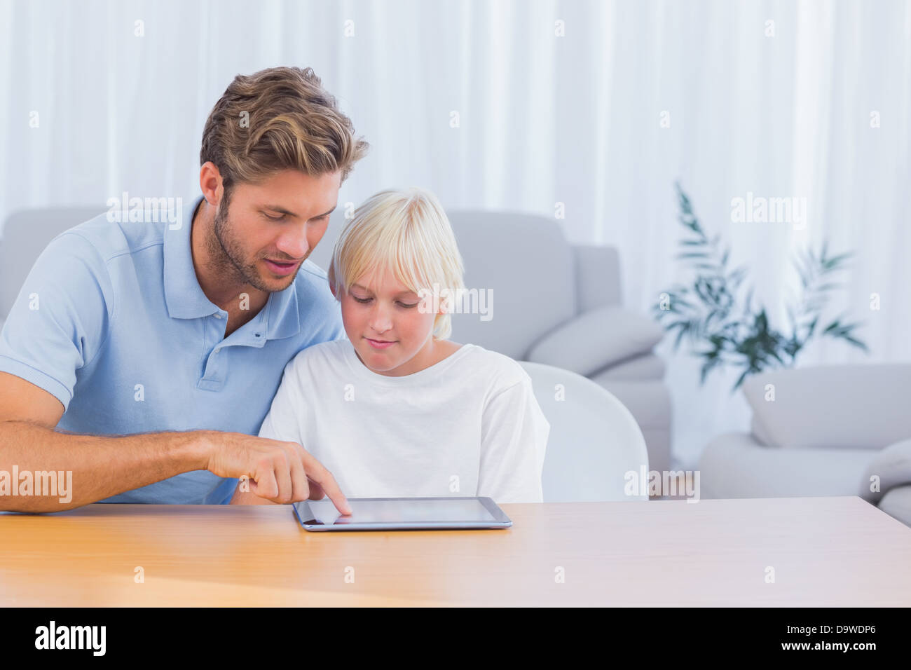 Father and son using tablet pc together Stock Photo - Alamy