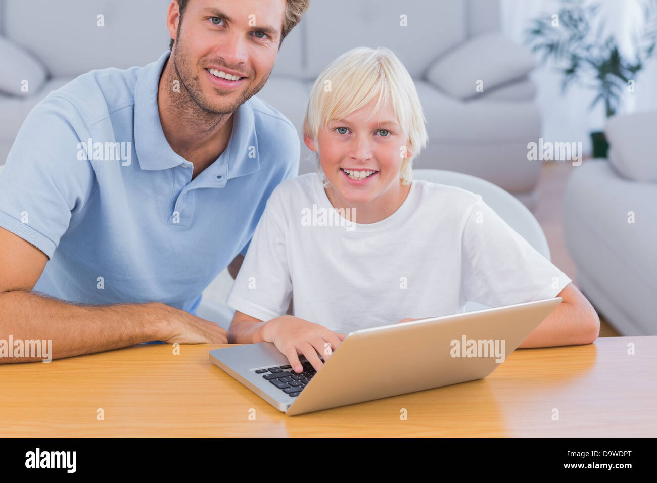 Smiling father and his son using laptop Stock Photo - Alamy