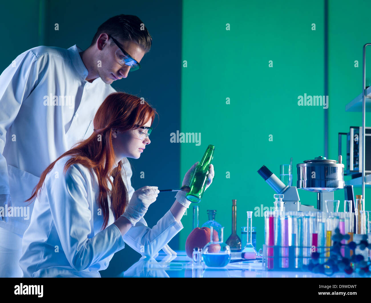 side view of two forensics scientists taking fingerprints from bottle ...