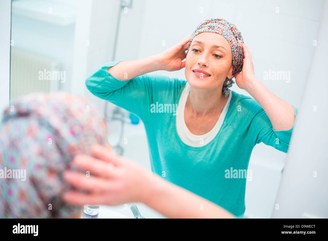 Woman undergoing chemotherapy, looking herself in a mirror Stock Photo ...