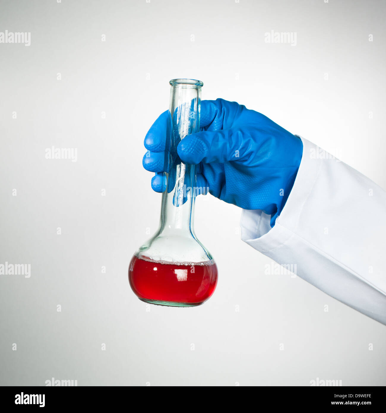light background with a round boiling flask containing a red ...